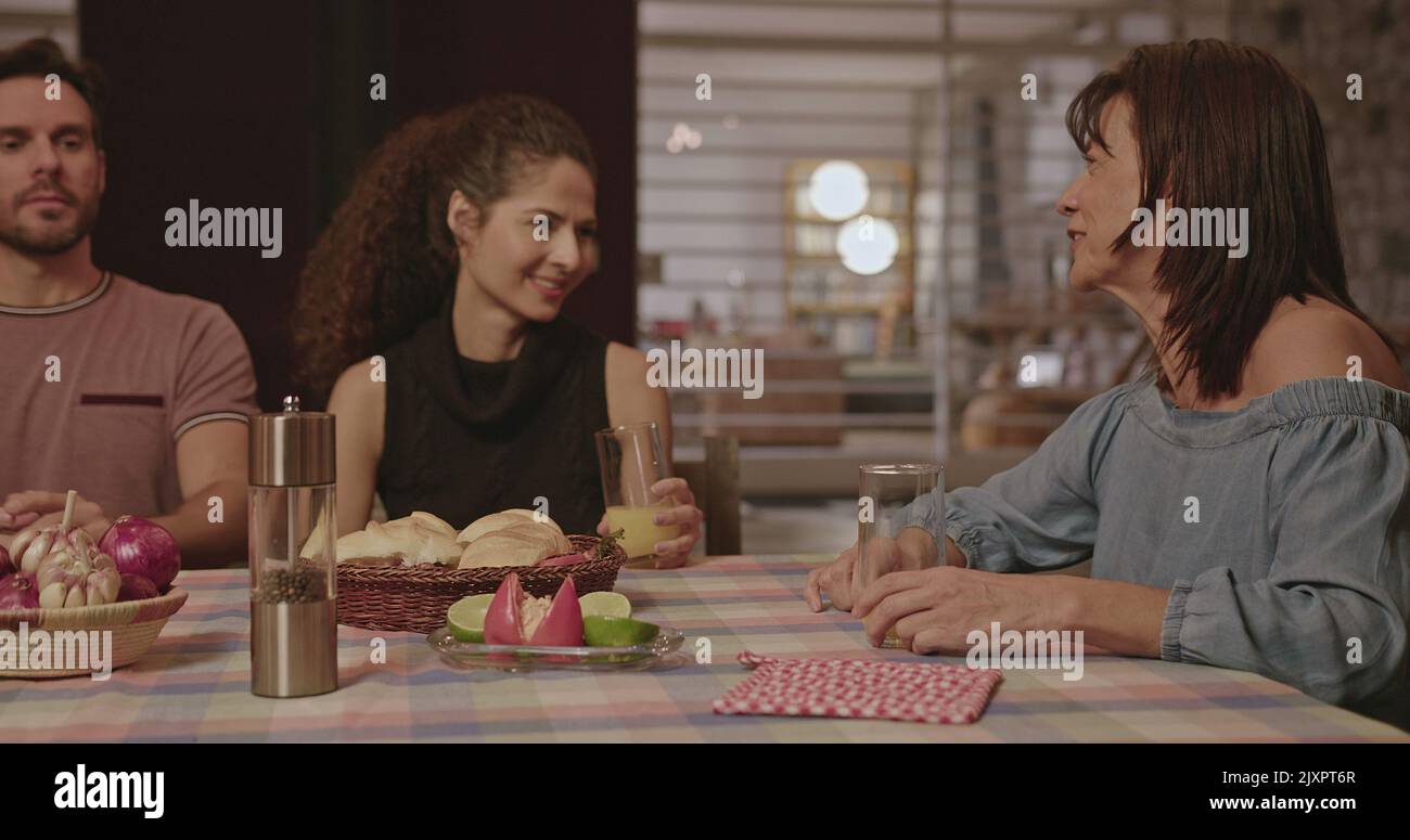 Family and friends in the evening together around the table in the ...