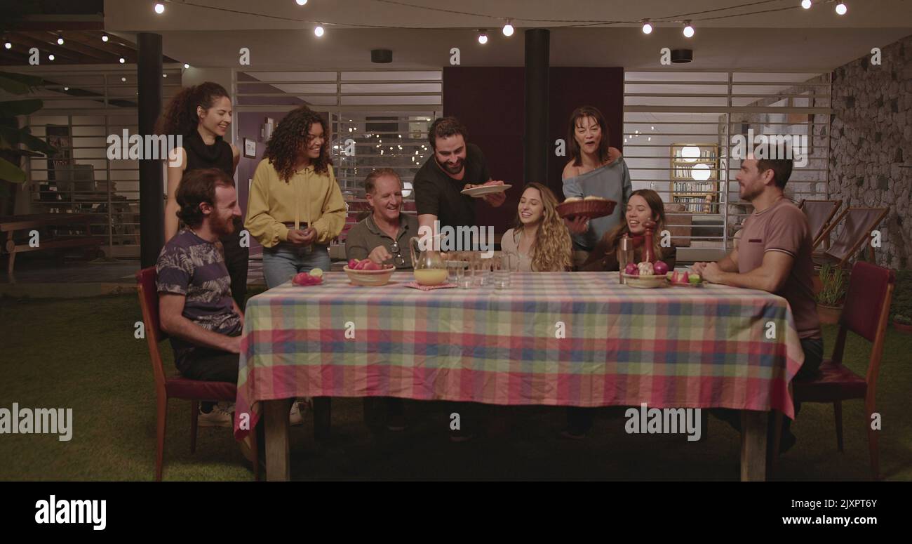 Group of happy people are sitting together in the backyard of the house ...