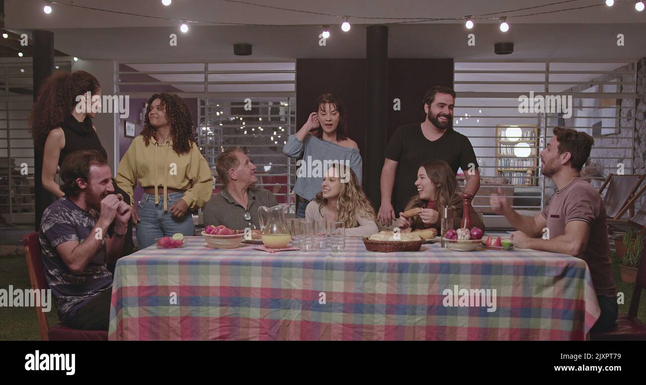 Group of happy people are sitting together in the backyard of the house ...