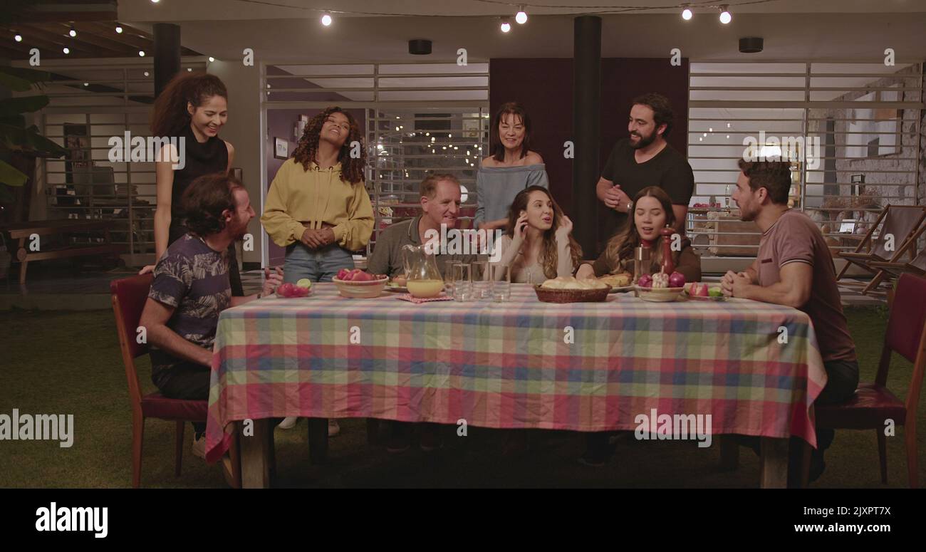 Group of happy people are sitting together in the backyard of the house ...