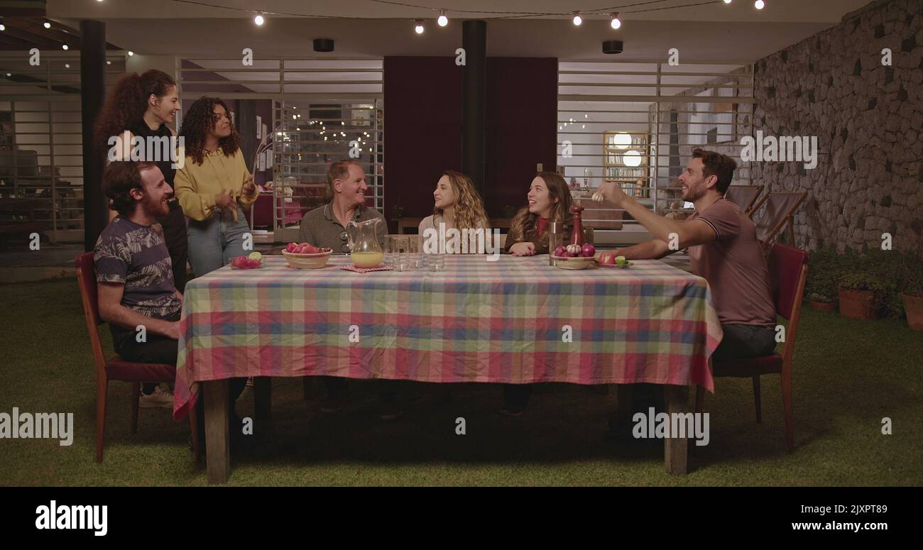 Group of happy people are sitting together in the backyard of the house ...