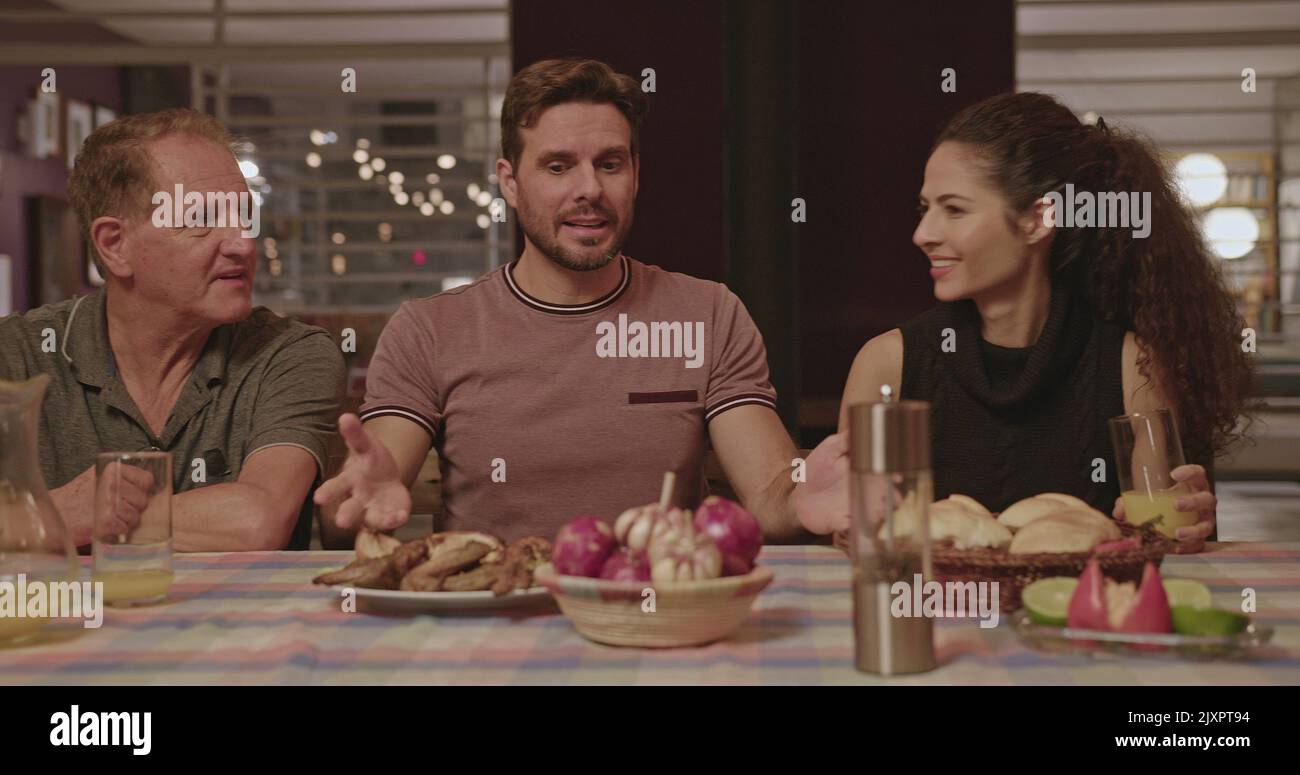 Family and friends in the evening together around the table in the ...