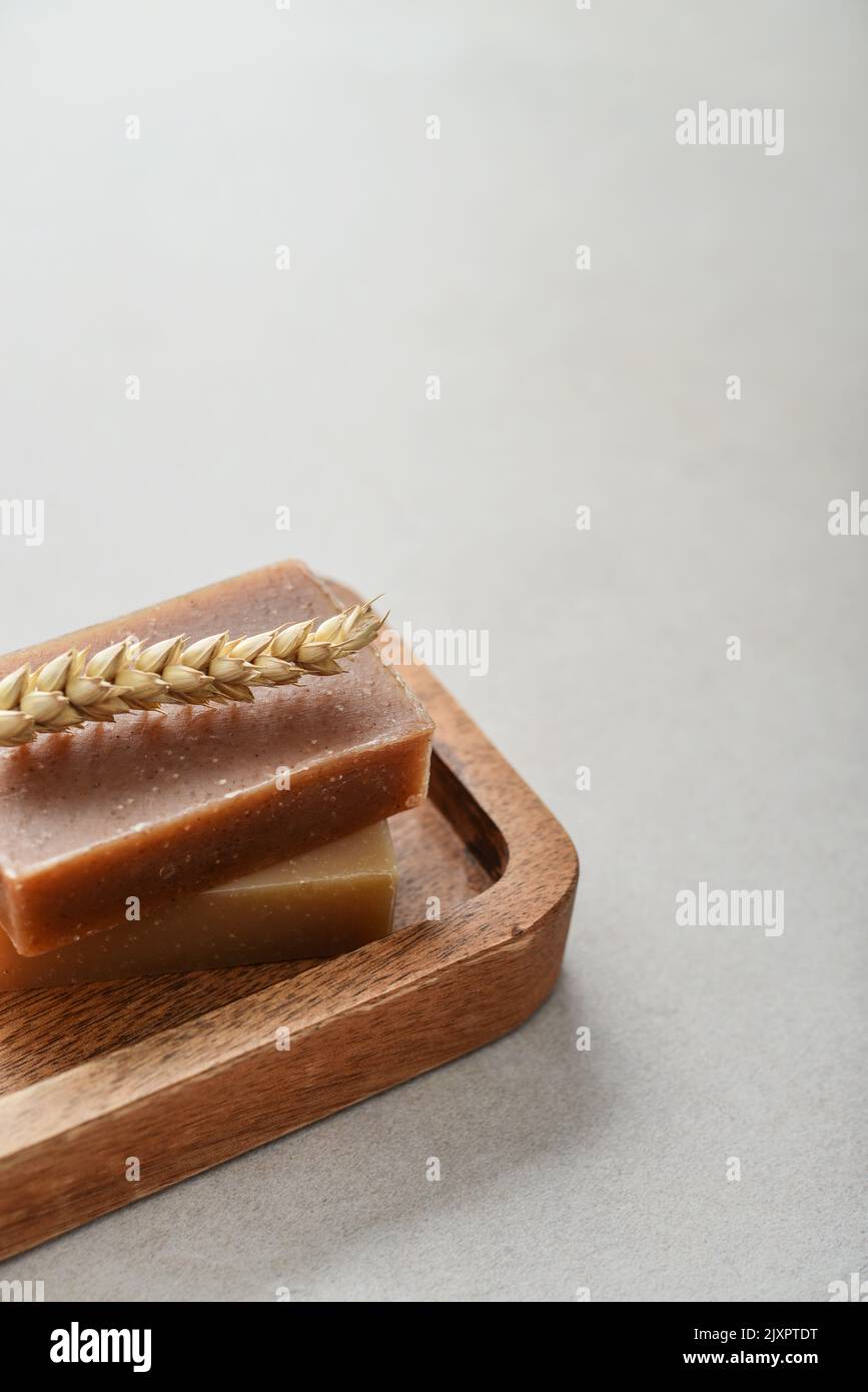 Natural handmade soap bars with wheat spikelet on wooden tray on a ...