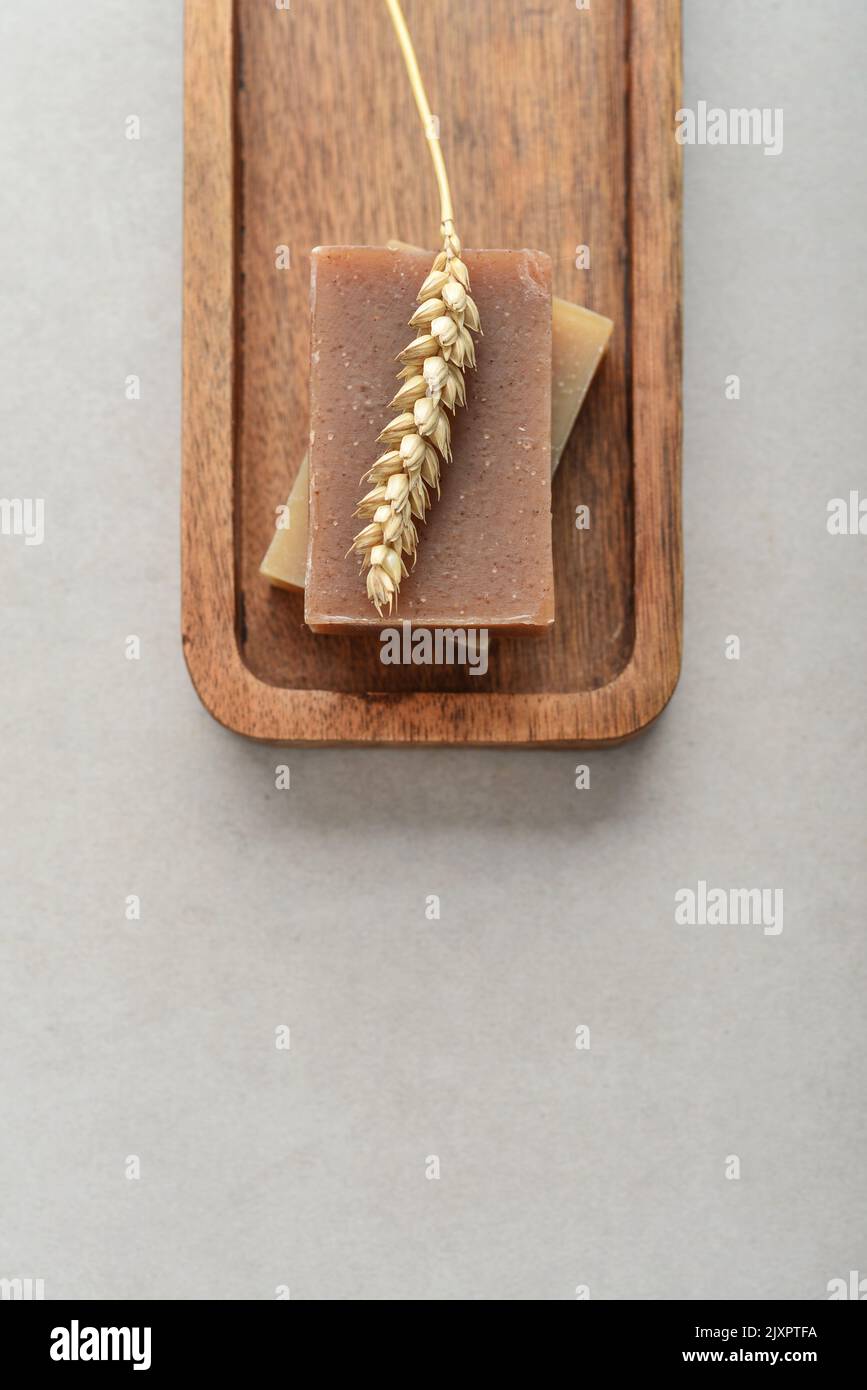 Natural handmade soap bars with wheat spikelet on wooden tray on a ...