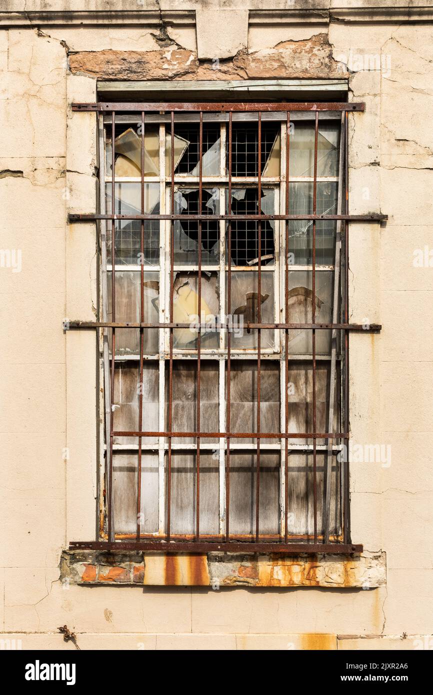 A barred window with broken glass Stock Photo - Alamy