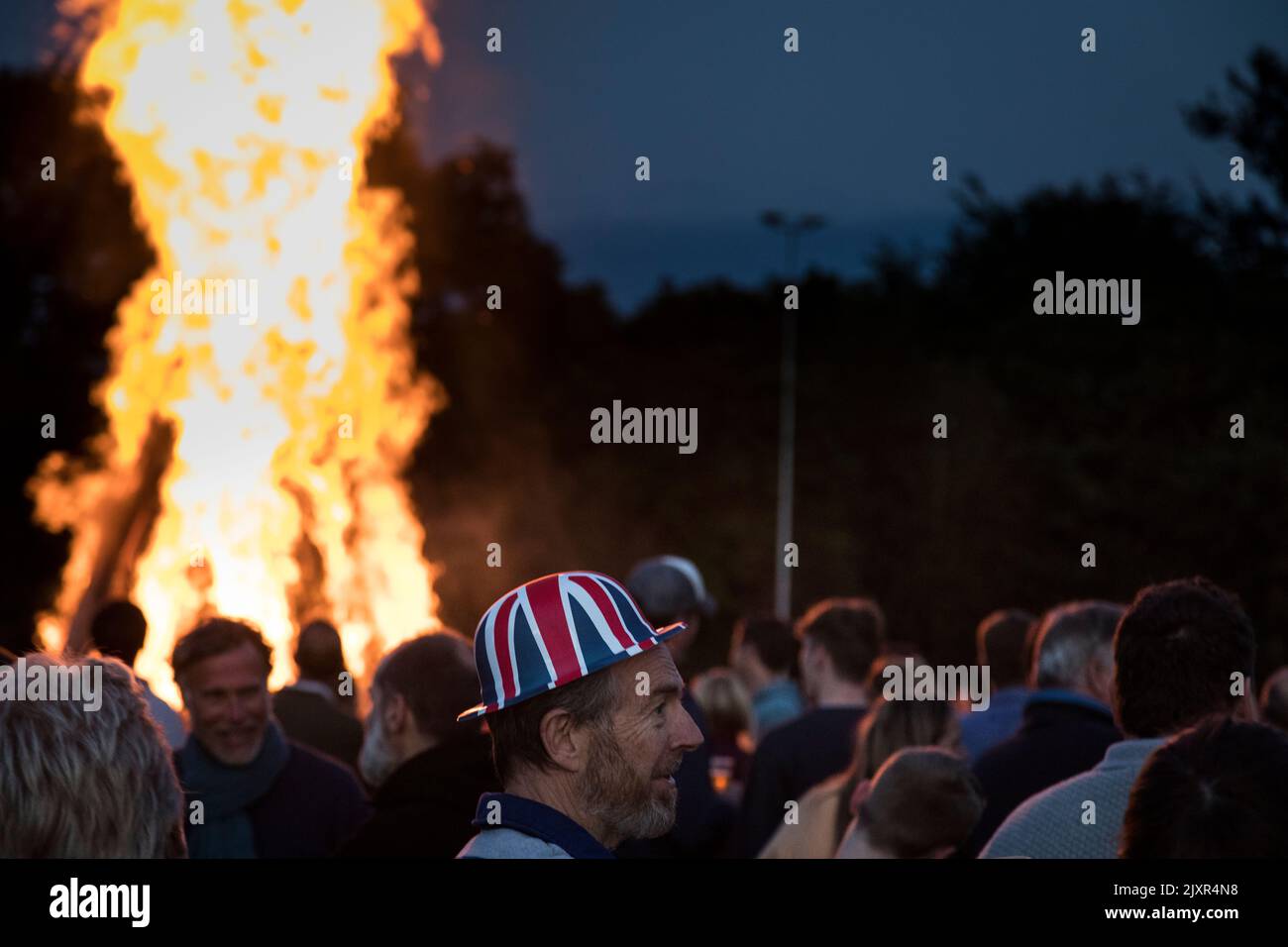 A man wears a Union flag hat as crowds watch the Queen's Platinum ...