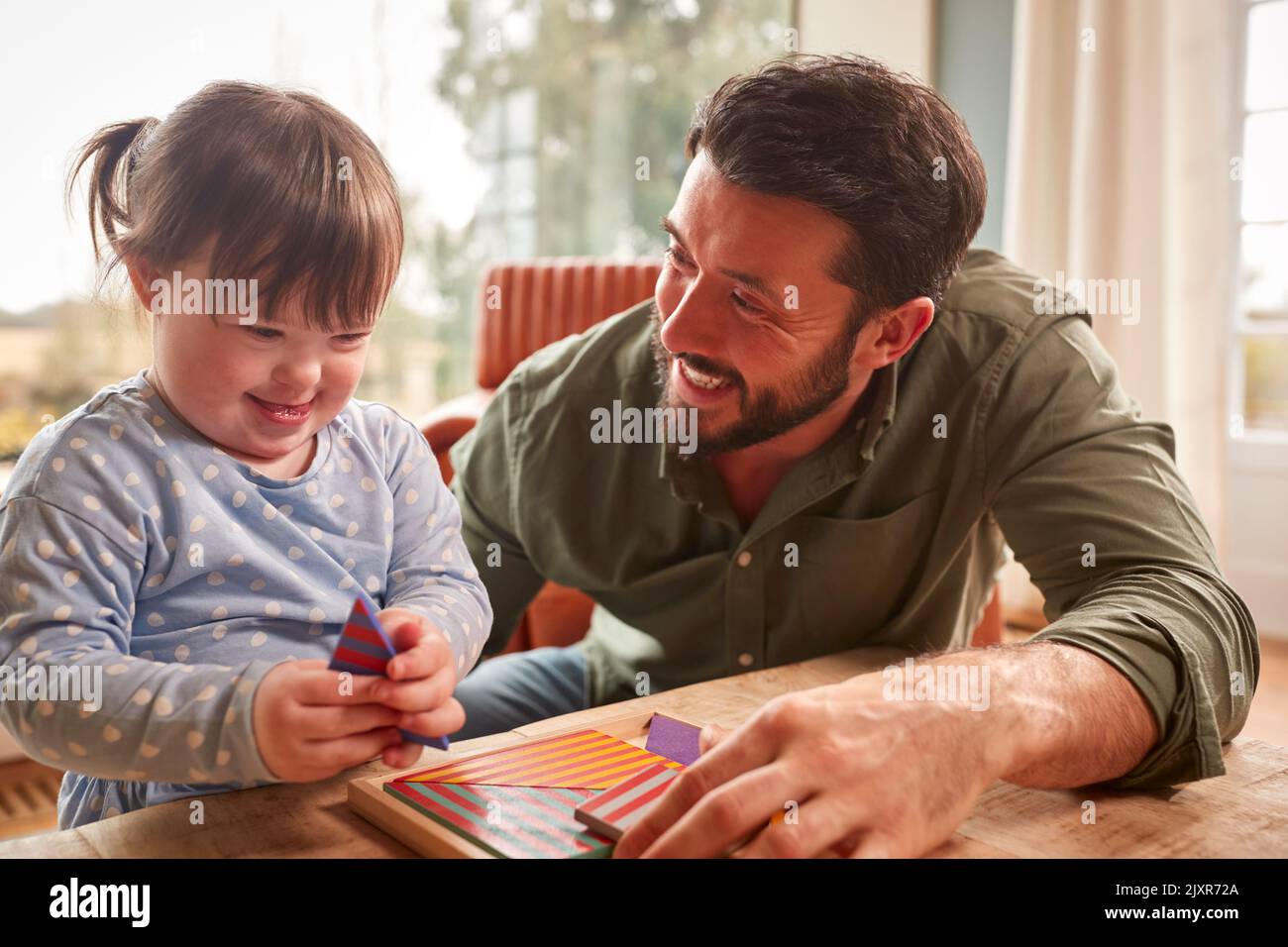 Father With Down Syndrome Daughter Playing Game With Wooden Shapes At ...