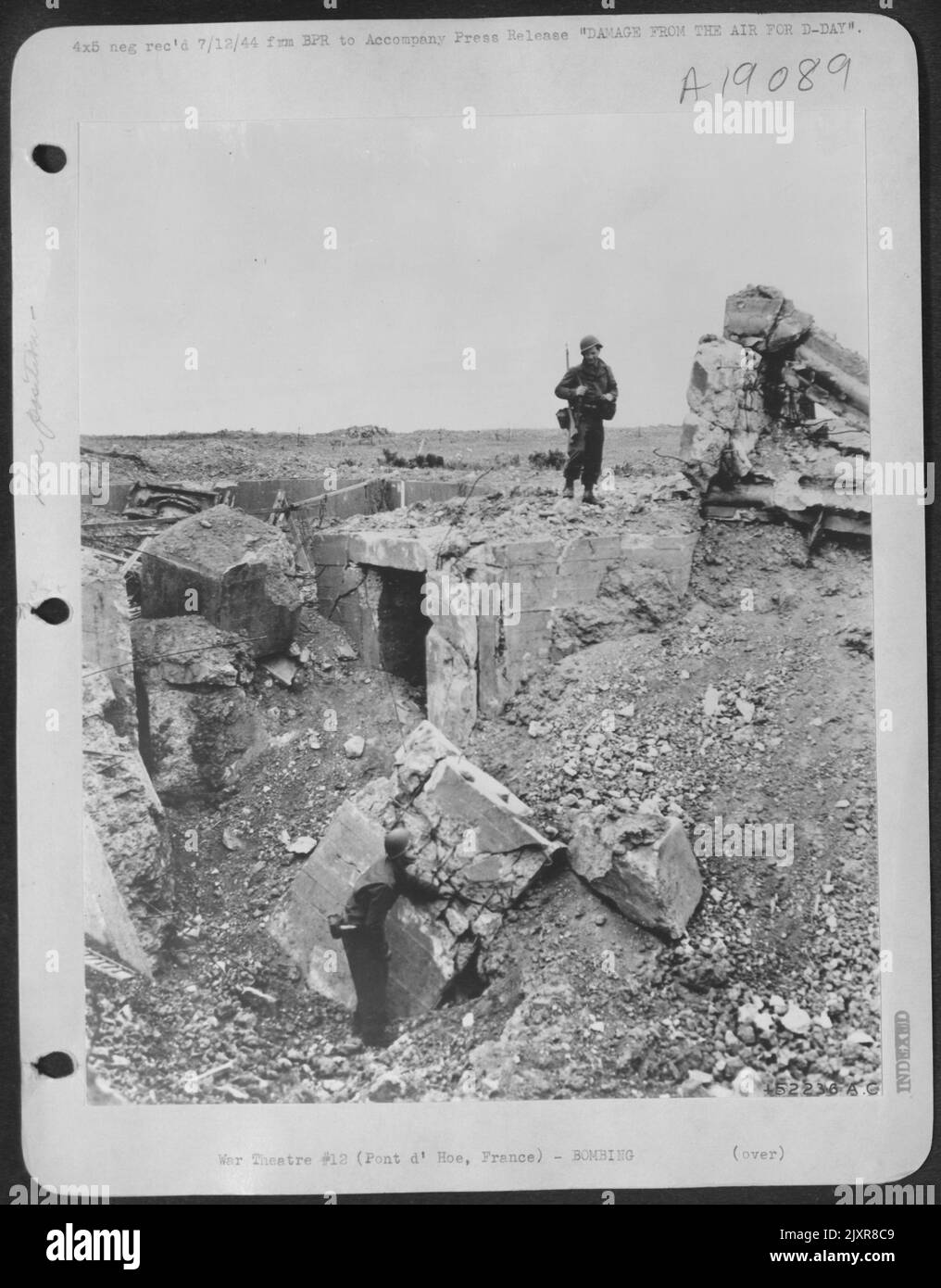 DAMAGE FROM THE AIR FOR D-DAY-Two American soldiers inspect the damage ...