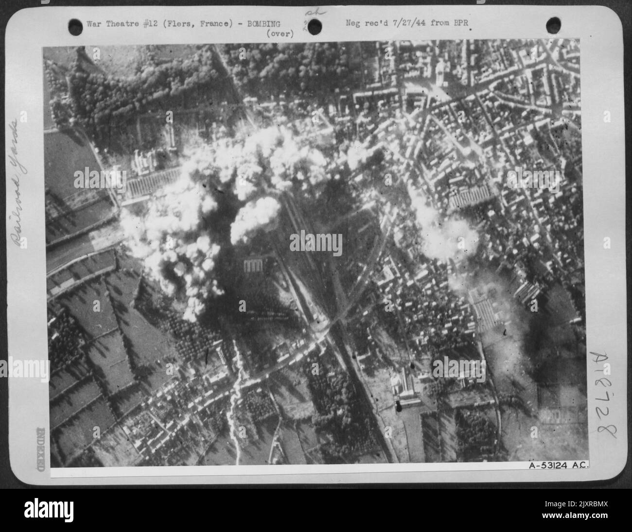 A compact pattern of bombs erupts on the rail yards and road ...