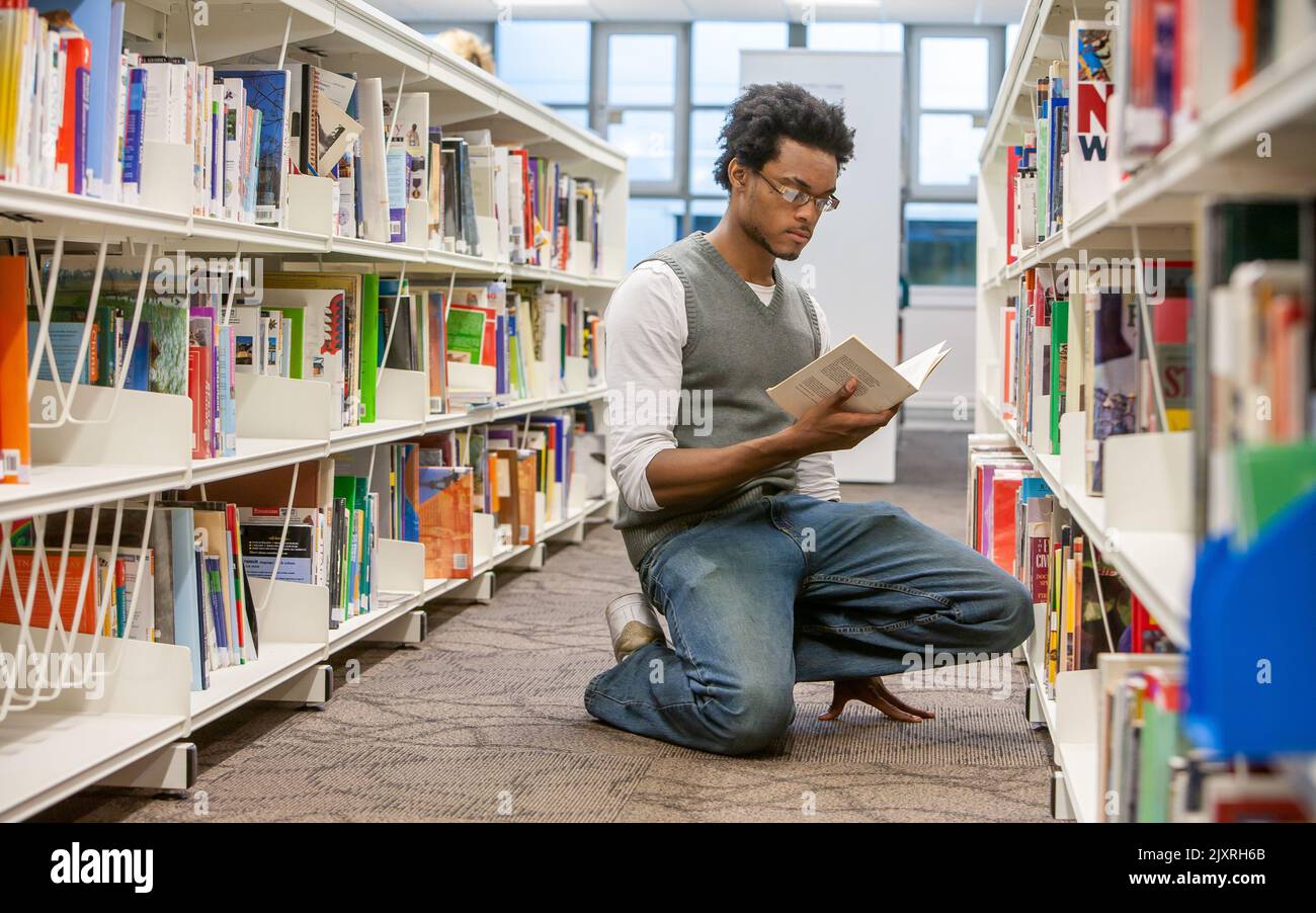 Teenage Students: Book Worm. A male student making use of his college ...