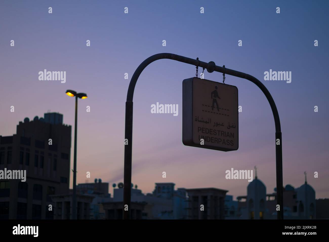 Close-up of pedestrian underpass road sign at twilight. Purple sky ...