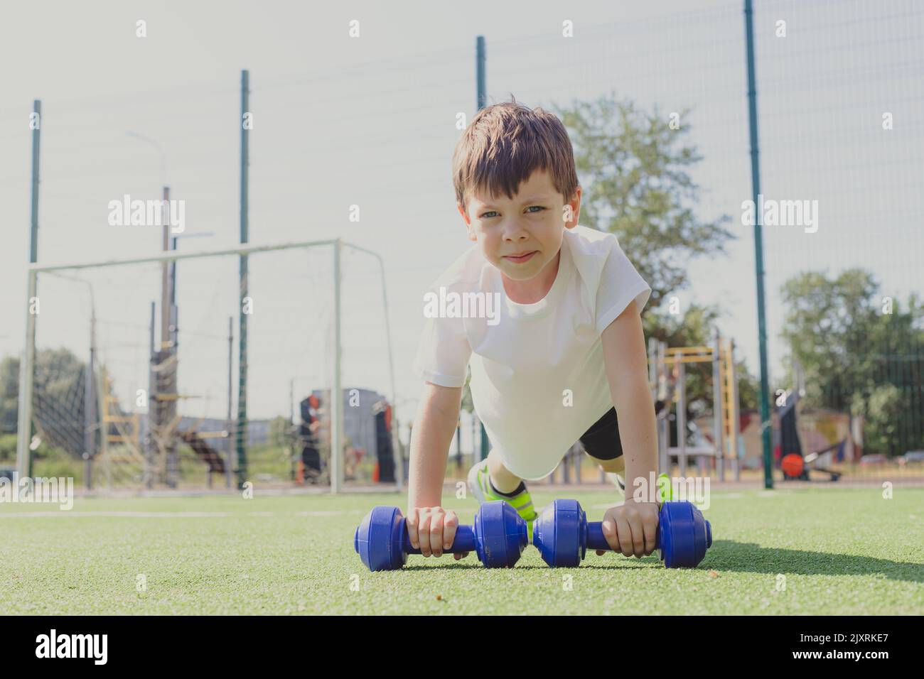 A child with dumbbells on the playground. A sporty kid. Illustrating an ...