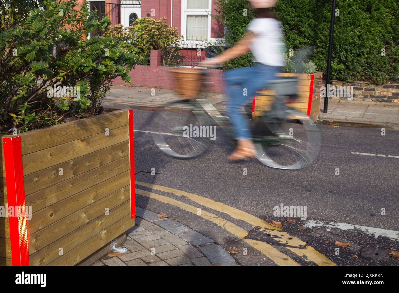 A cyclist passes through barriers signalling a controversial LTN (Low ...