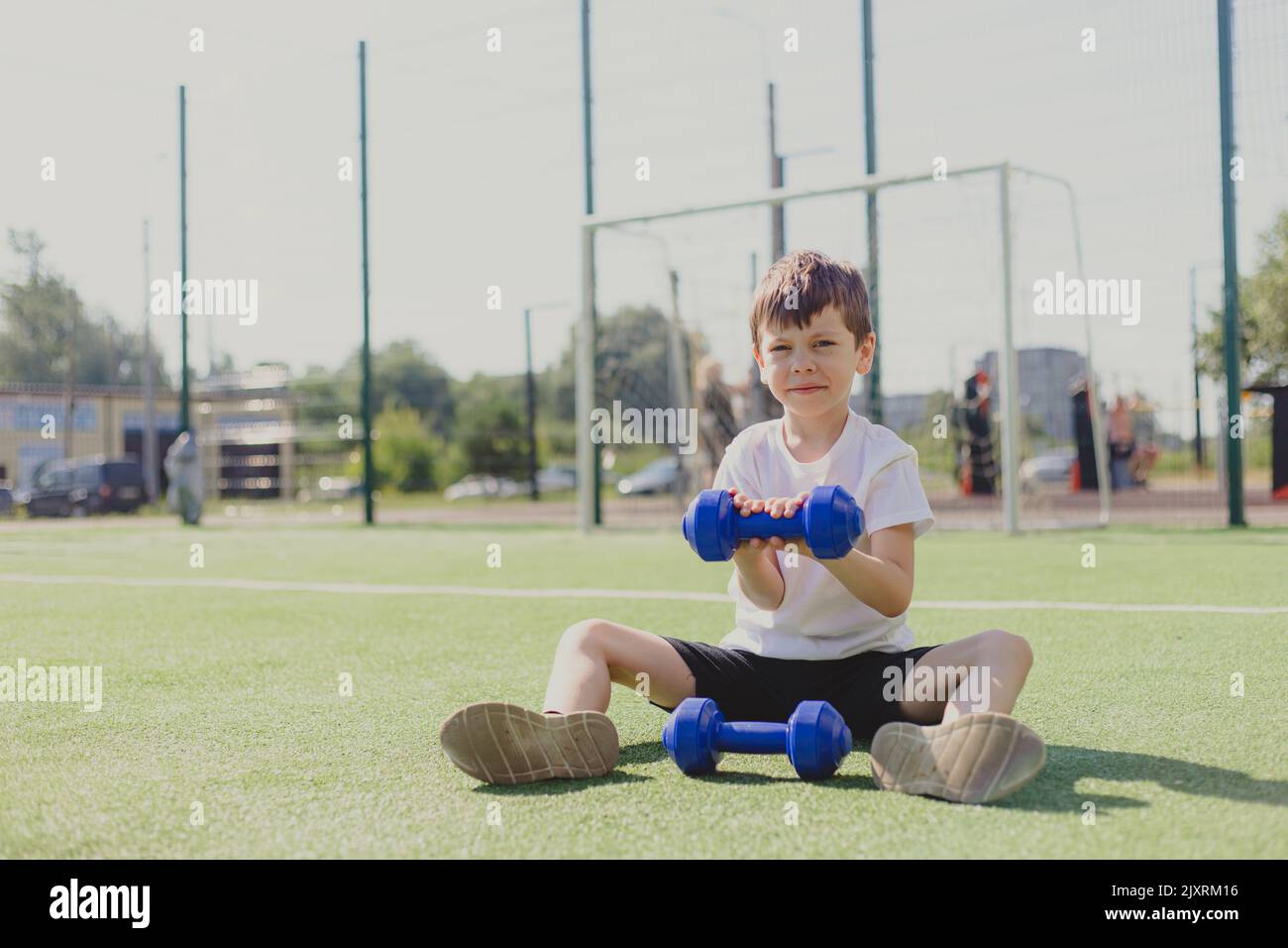 A child with dumbbells on the playground. A sporty kid. Illustrating an ...