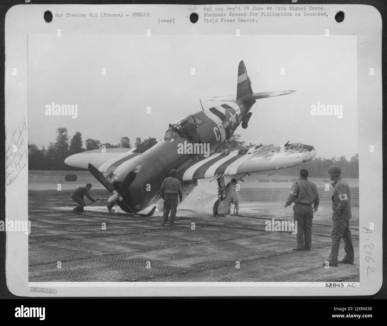 Ground crewmen extinguish a fire started under the P-47 that ...