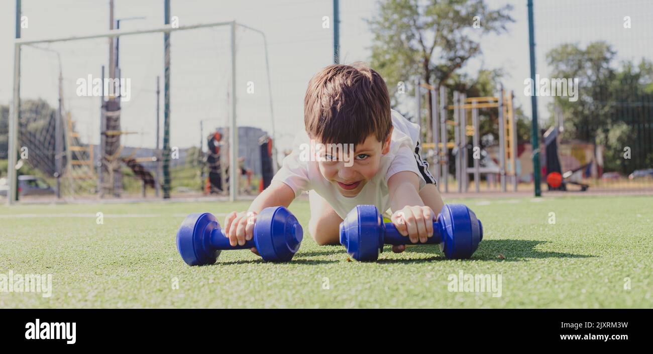 A child with dumbbells on the playground. A sporty kid. Illustrating an ...