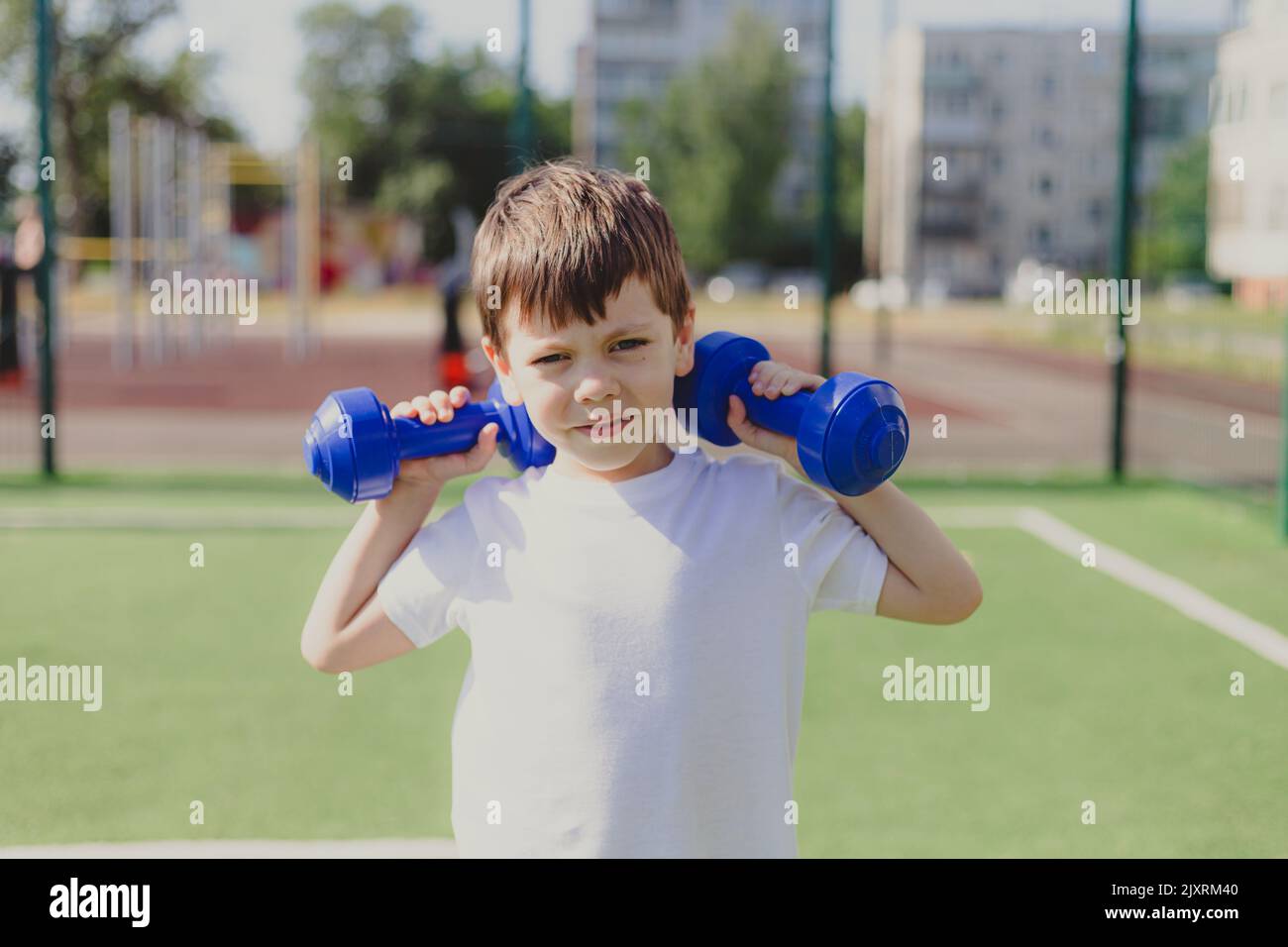 A child with dumbbells on the playground. A sporty kid. Illustrating an ...