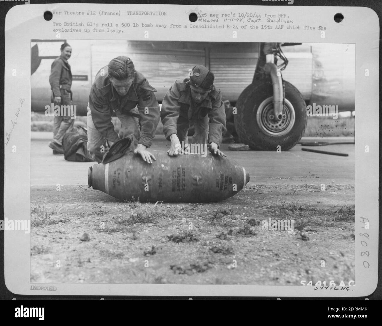 Two British GI's roll a 500 lb bomb away from a Consolidated B-24 of ...