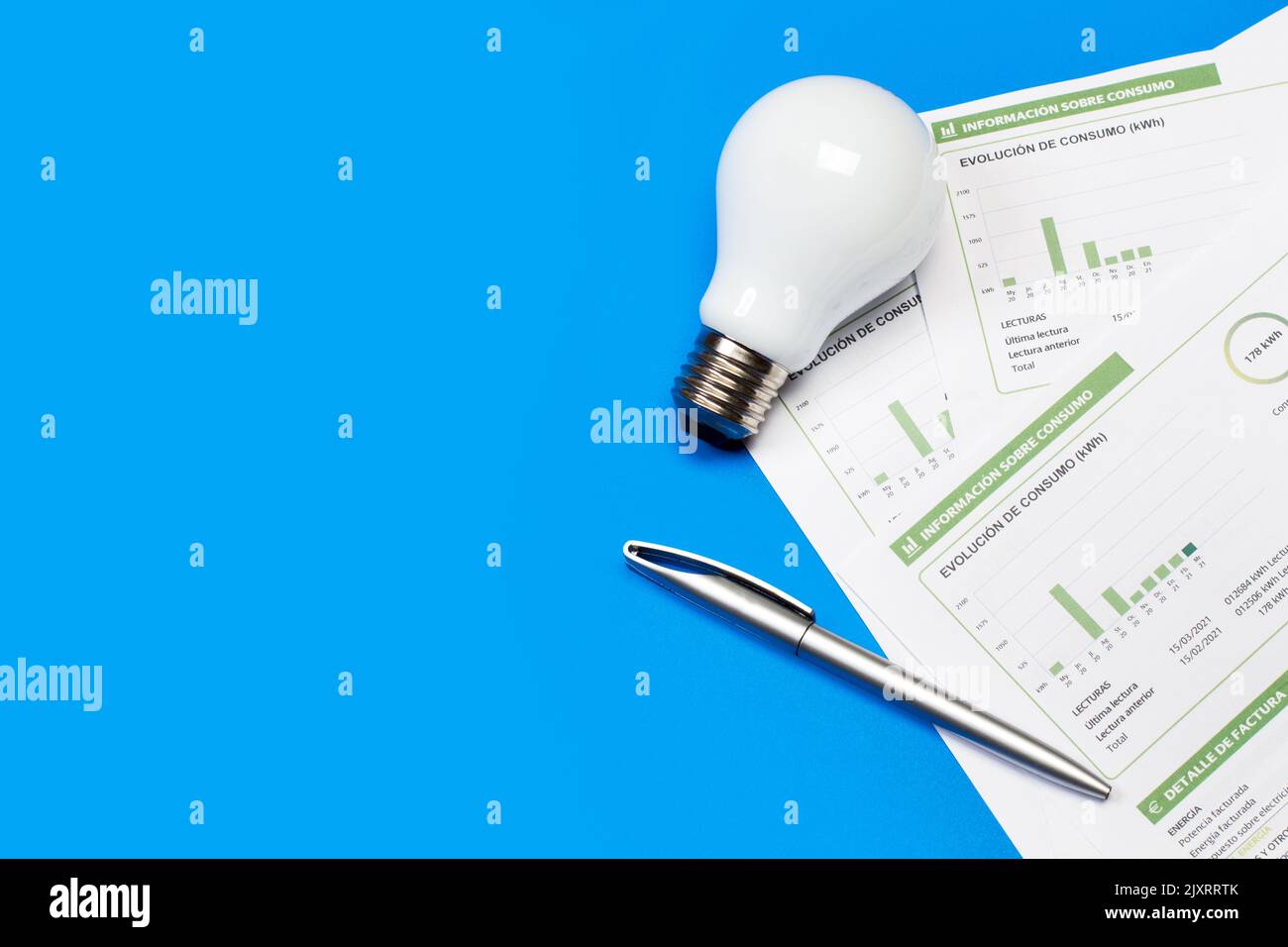 A lightbulb and an electricity bill on a blue background in a top view ...