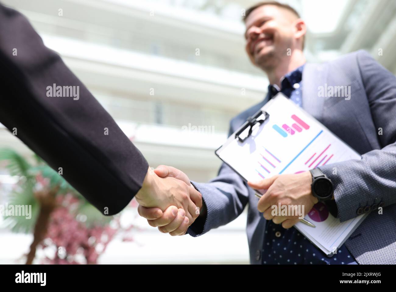 Handshake of businessmen with financial analytics charts Stock Photo ...