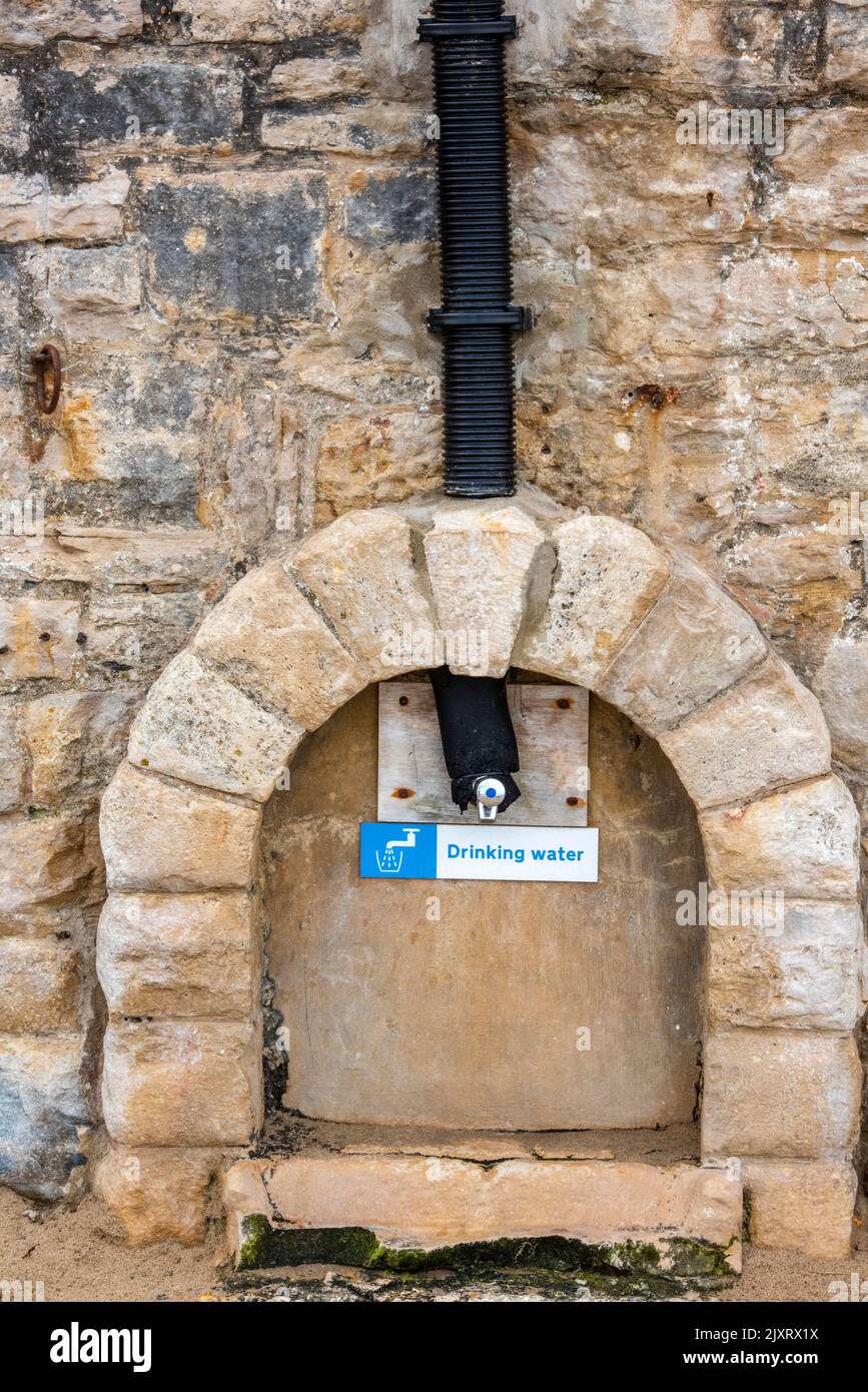 fresh water drinking water fountain in a niche in a wall on the ...
