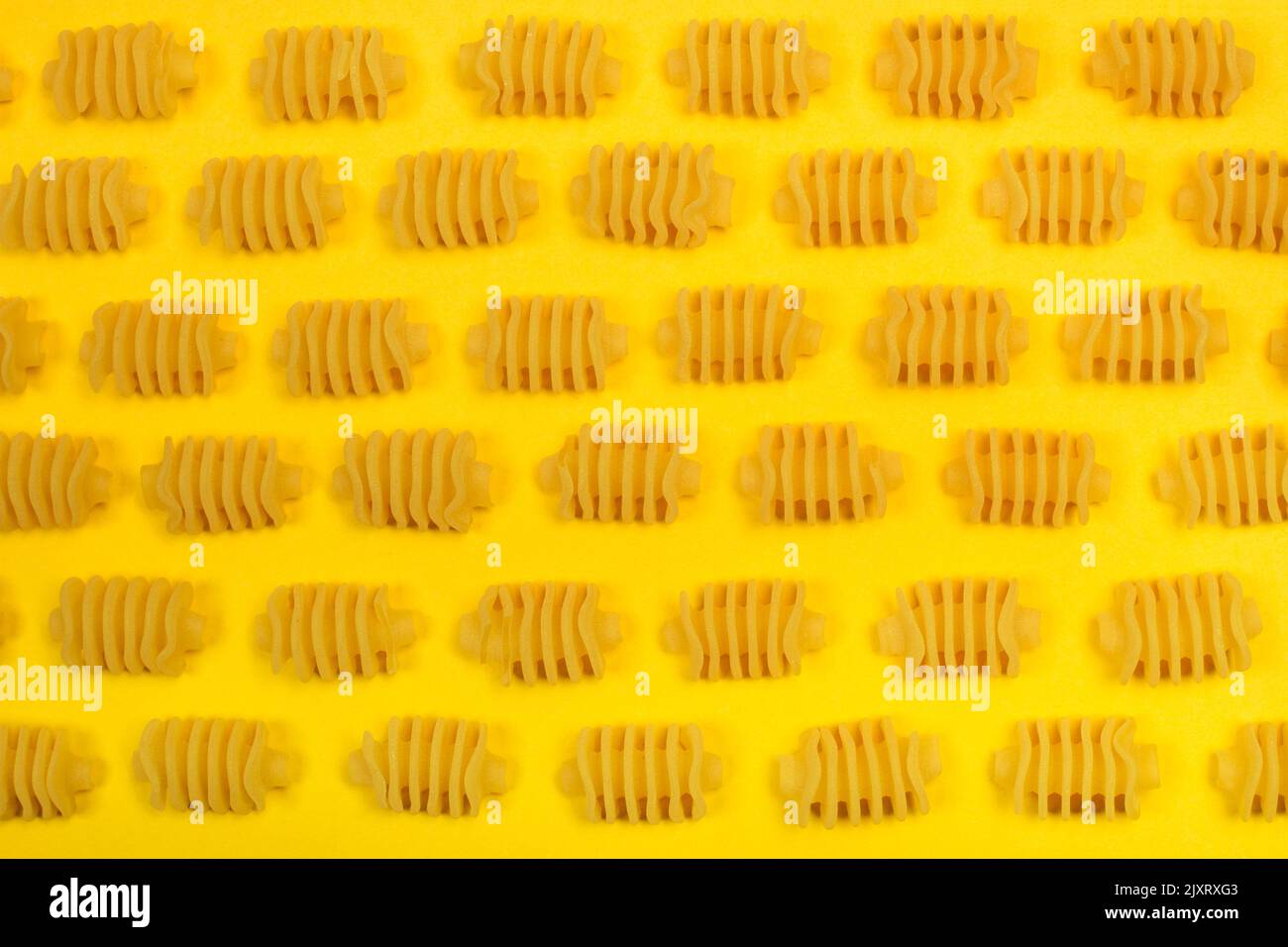 Dry radiatori pasta on a yellow background in a top view Stock Photo ...