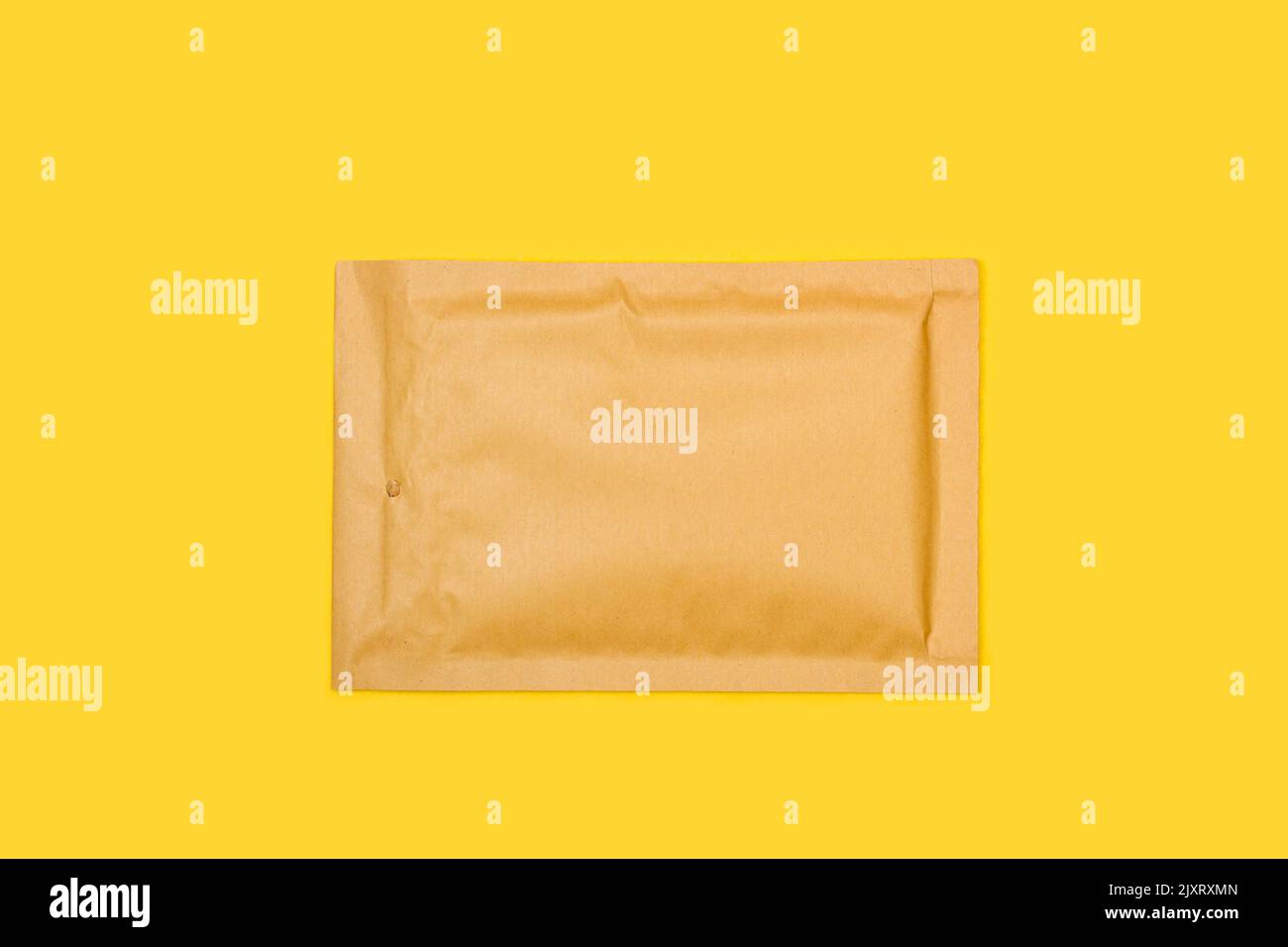 A brown padded envelope on a yellow background with copy space Stock ...