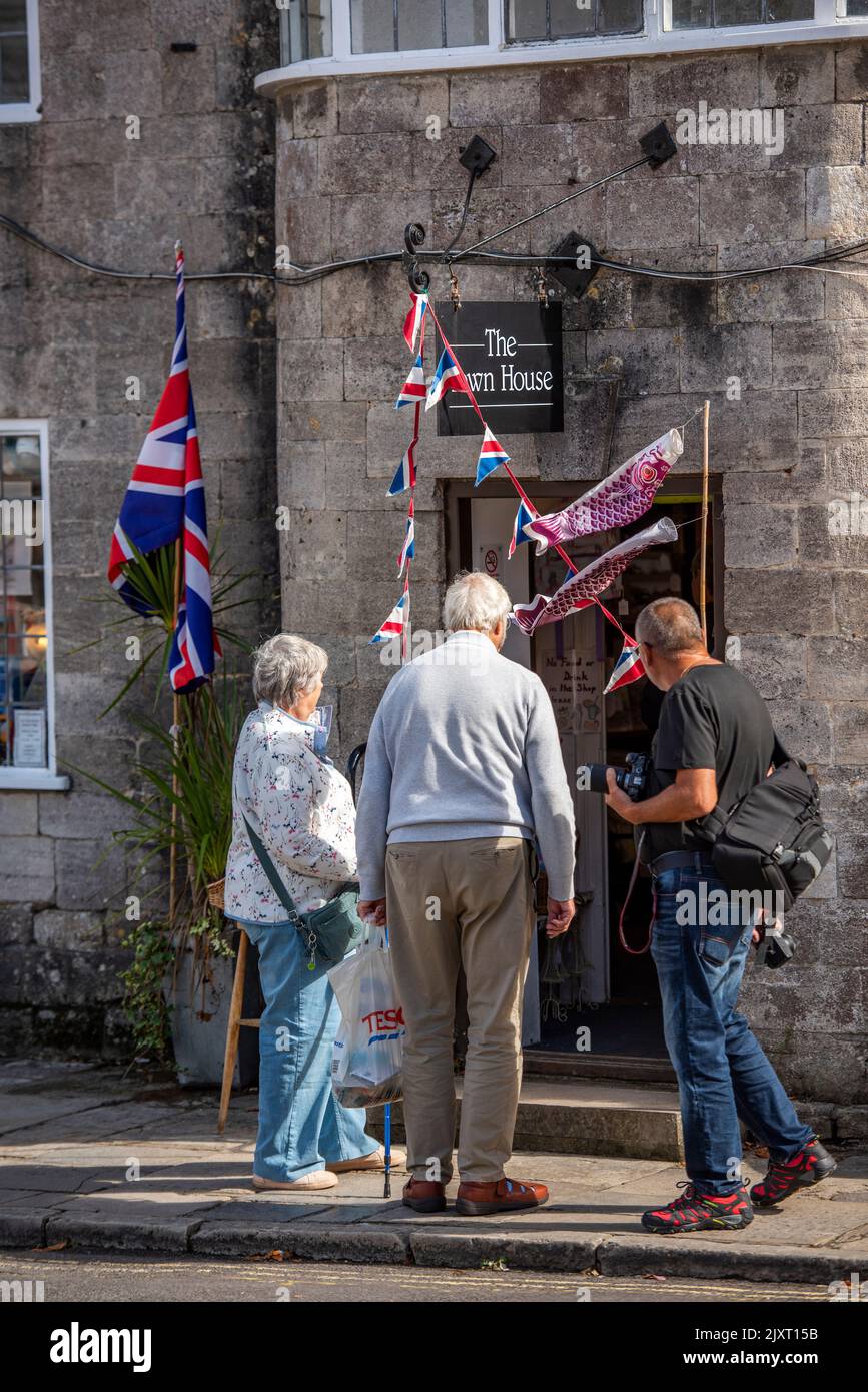 group of tourists outside of a souvenir shop in corfe castle dorset ...