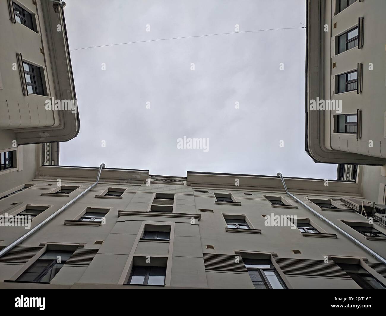 A courtyard with a low angle view. Sky surrounded by buildings and ...