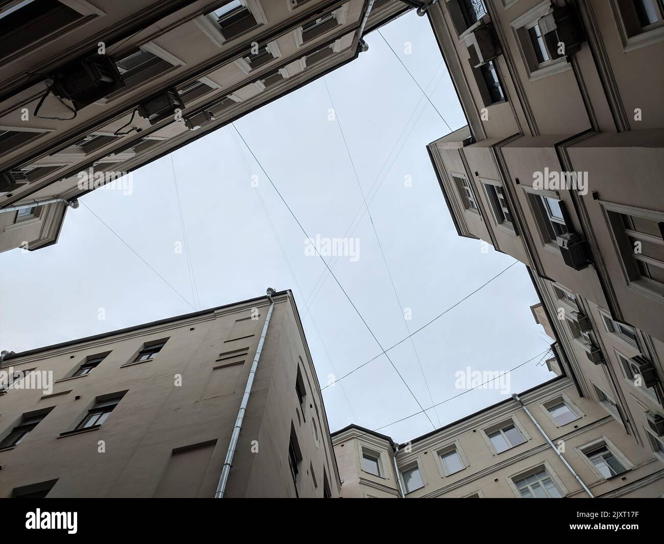 A courtyard with a low angle view. Sky surrounded by buildings and ...
