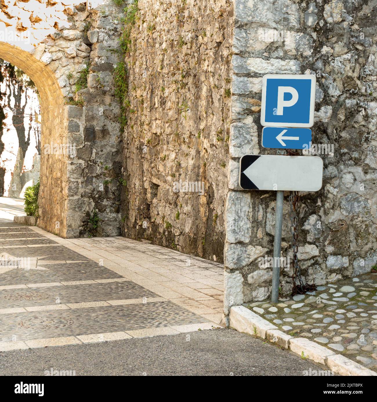 direction sign with empty space and parking sign in a medieval street ...
