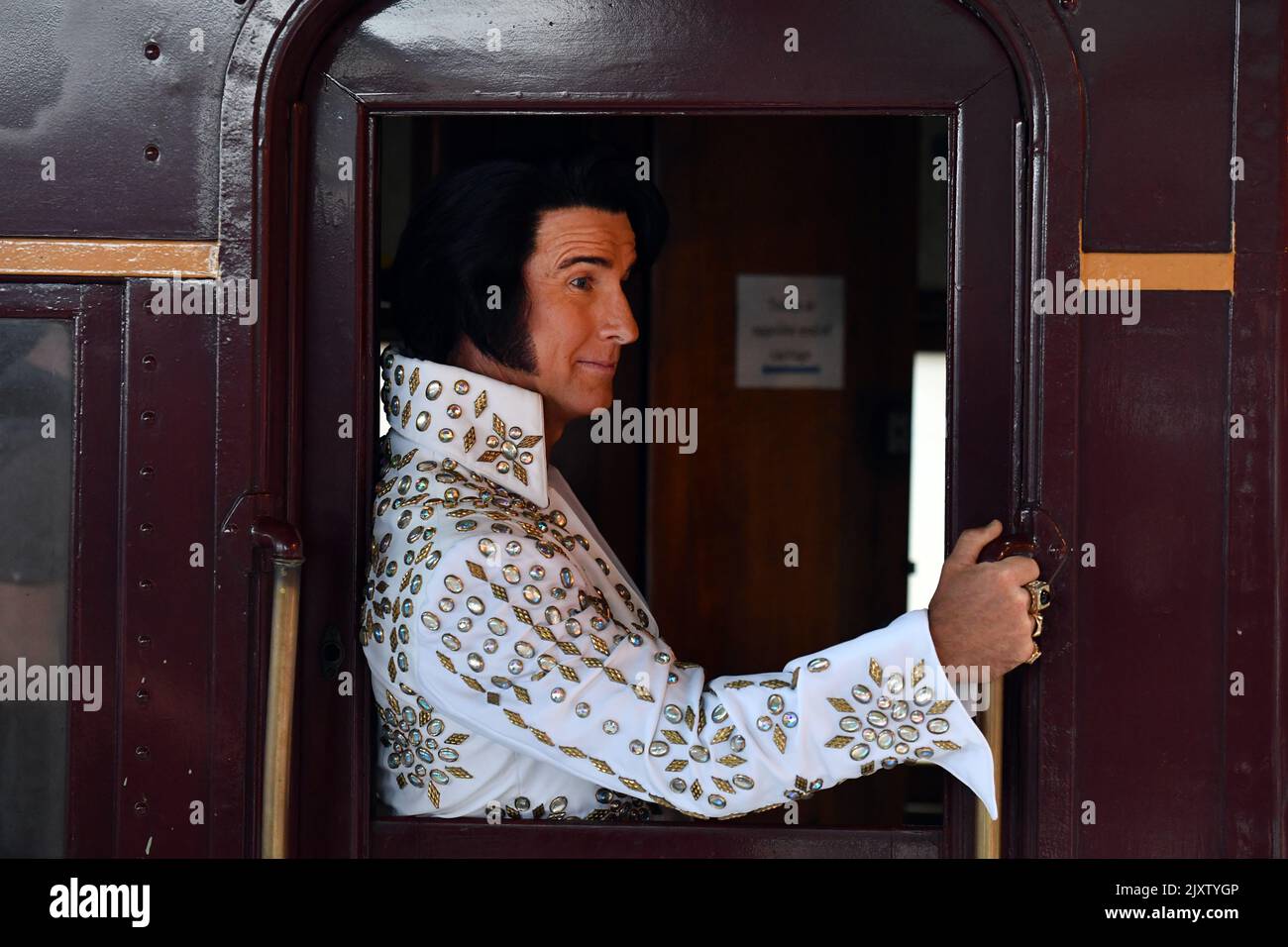 Elvis impersonator Kingsley Rock poses for a photograph before boarding ...