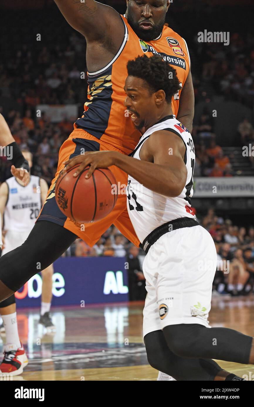 Melbourne's Casper Ware crashes into Taipans Nathan Jawai during the Round 13 NBL match between ...