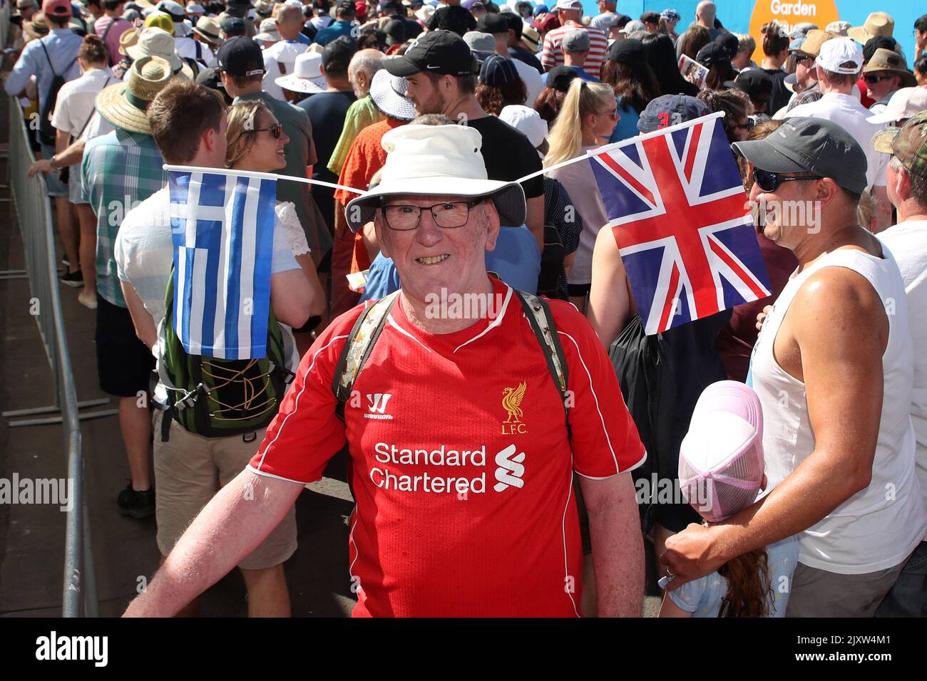 A fan poses with a flag at the entrance gates on day one of the ...