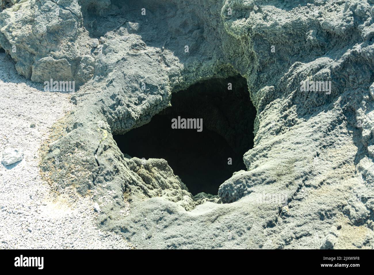 vent of a volcanic fumarole in the ground, covered with crystalline ...
