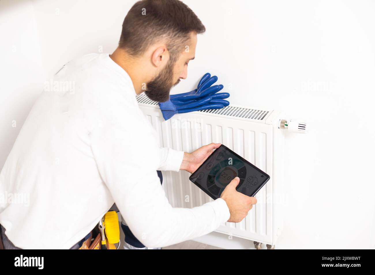 man repairing radiator with wrench. Removing air from the radiator ...