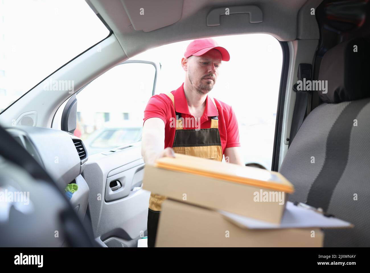 Young delivery man is loading boxes into car Stock Photo - Alamy