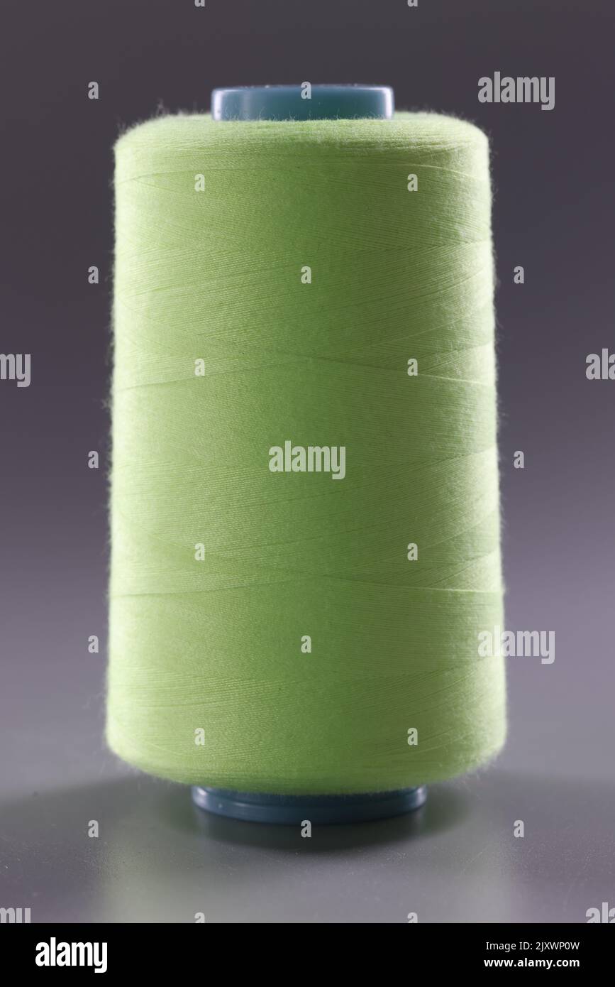 Light green spool of thread on gray background Stock Photo - Alamy
