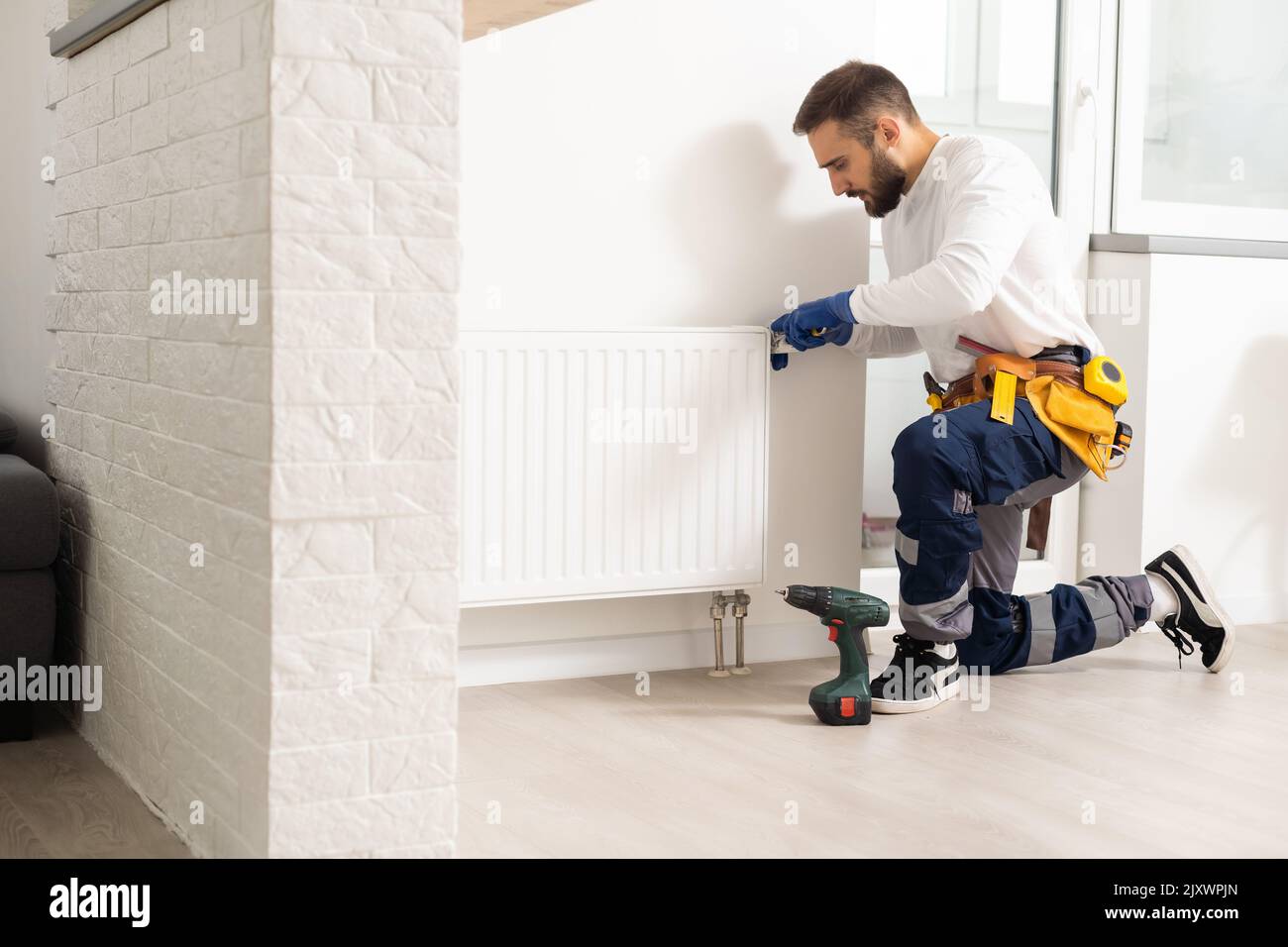 man repairing radiator with wrench. Removing air from the radiator ...