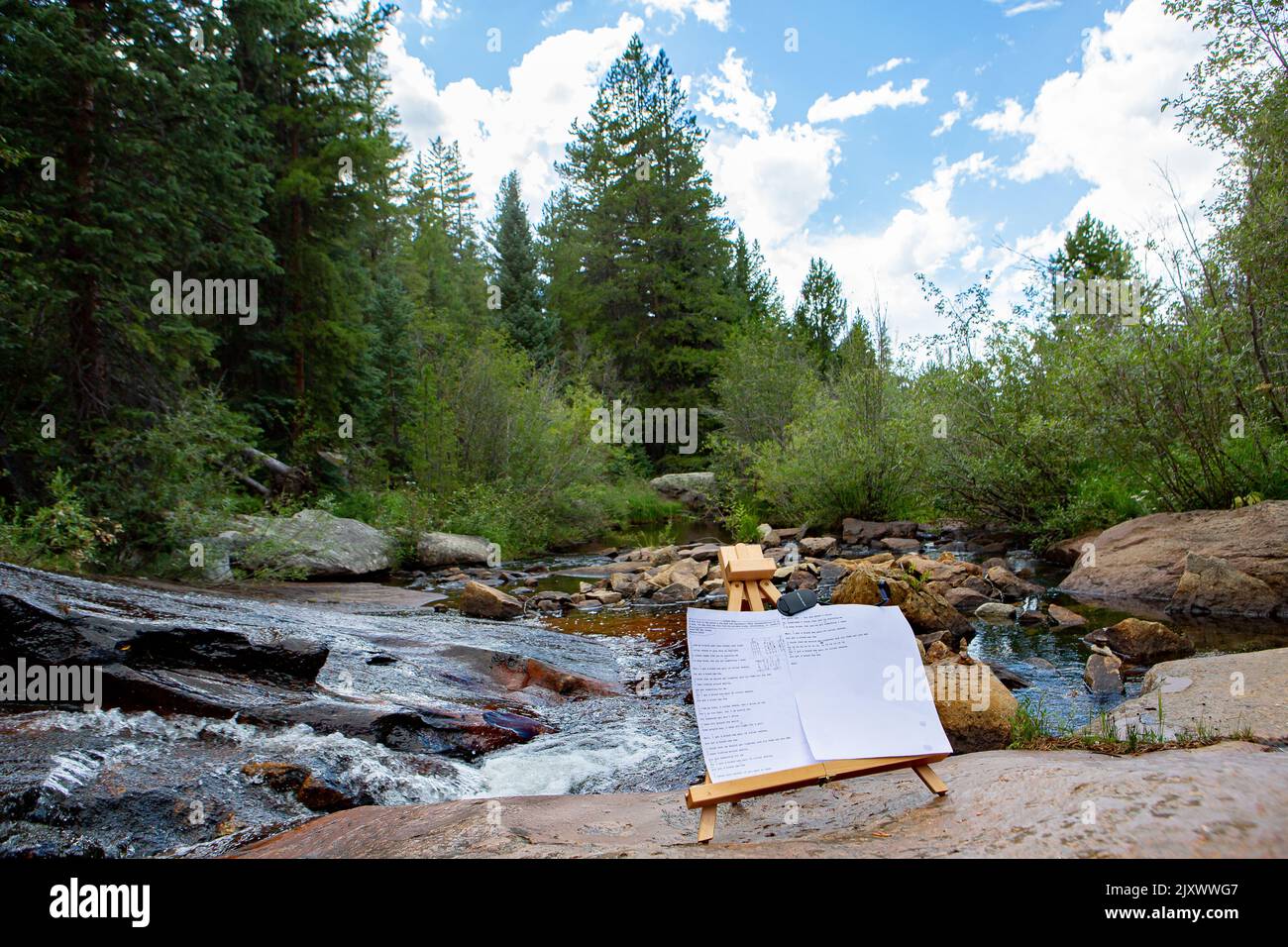 Playing music by a mountain river Stock Photo - Alamy