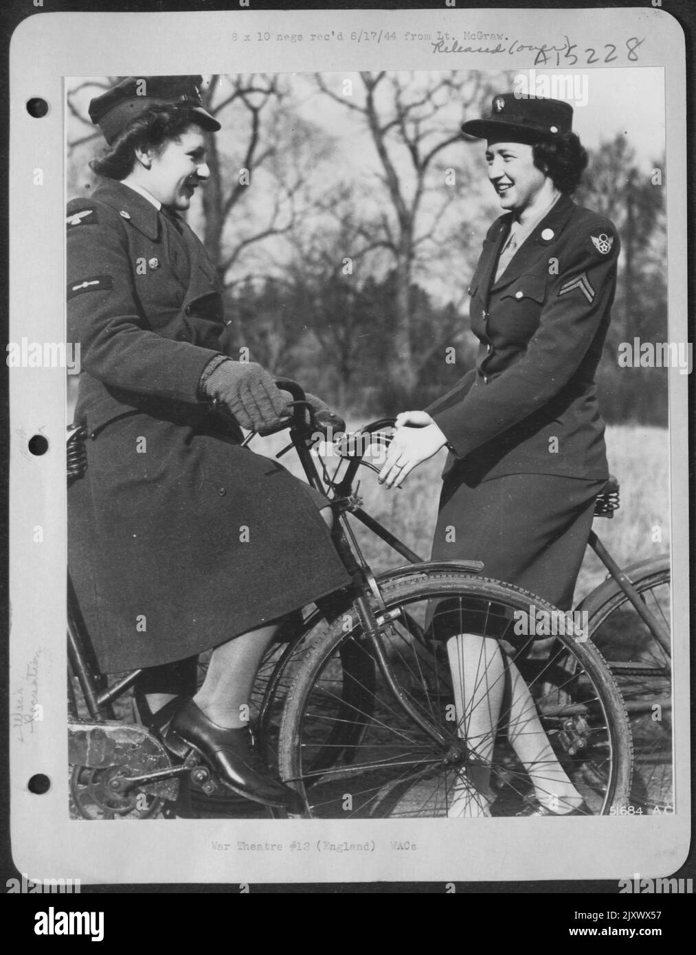 A WAC and her English counterpart, a WAAF, meet while out cycling in ...