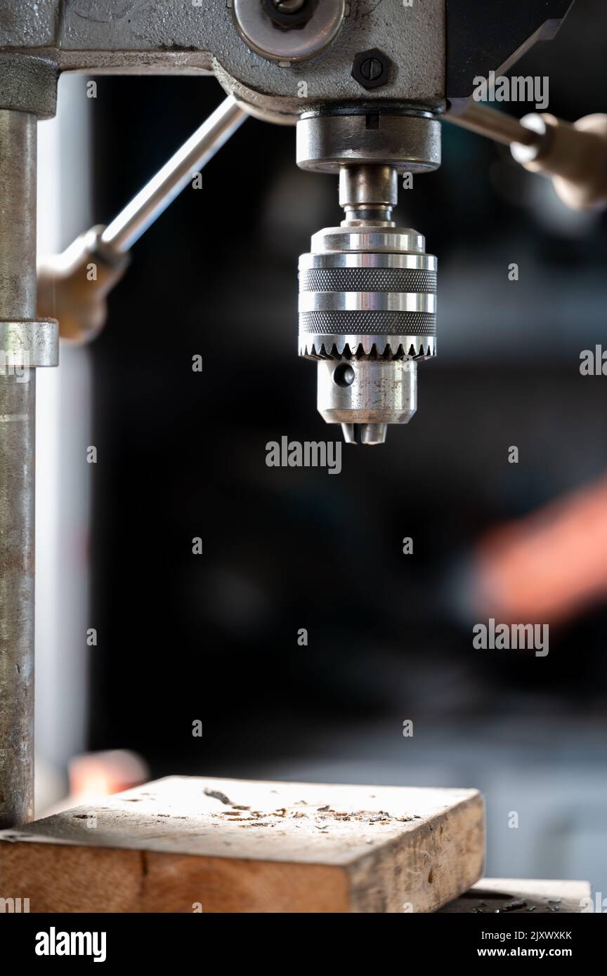 Industrial drill press with wooden board underneath Stock Photo - Alamy