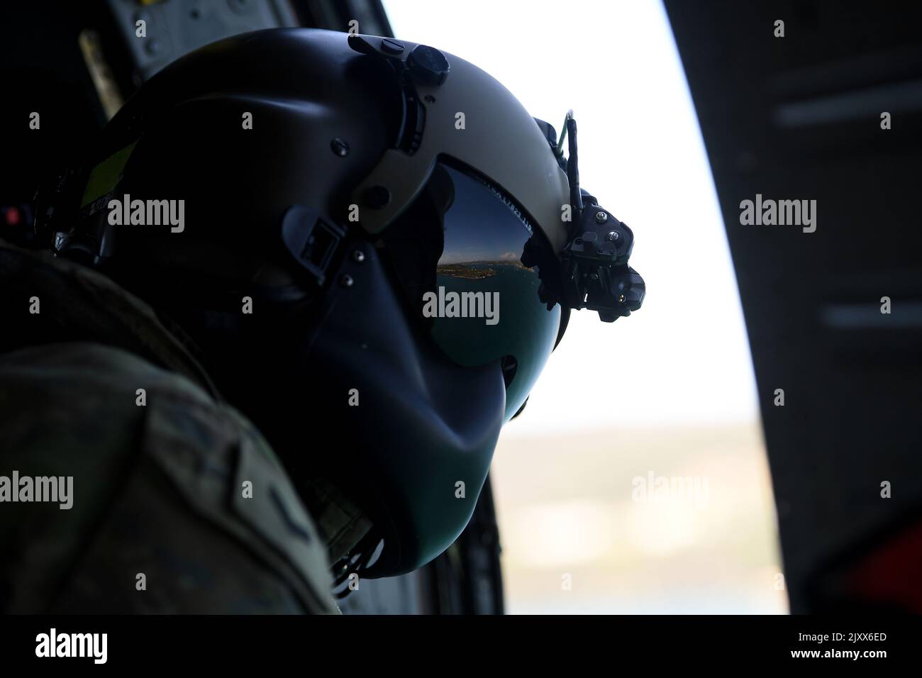 An Australian Army loadmaster looks out from a Black Hawk helicopter ...