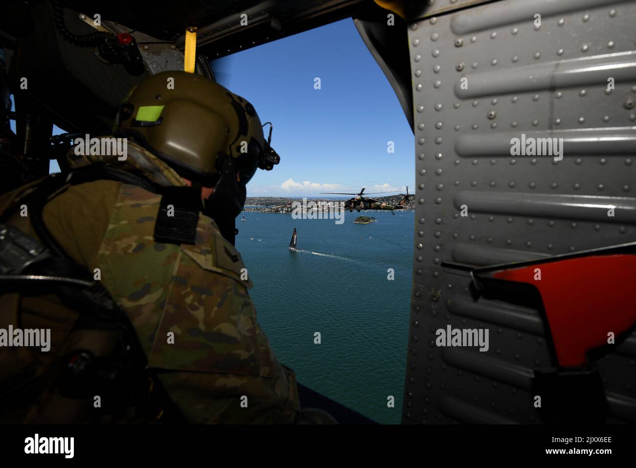 An Australian Army loadmaster looks out from a Black Hawk helicopter ...