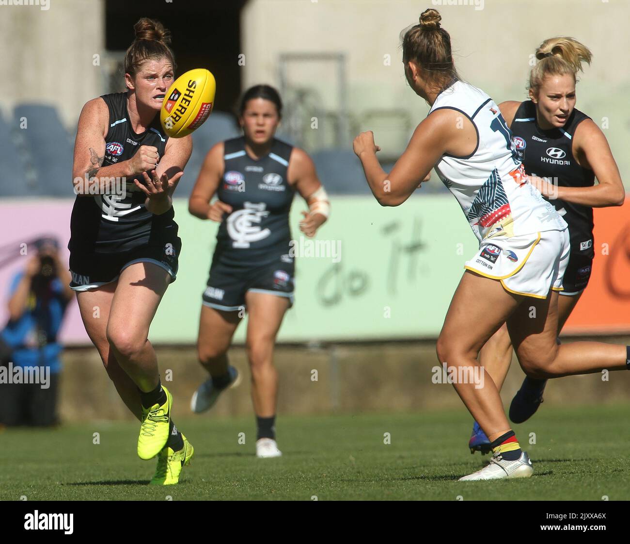 Brianna Davey of the Blues handpasses under pressure from Danielle ...