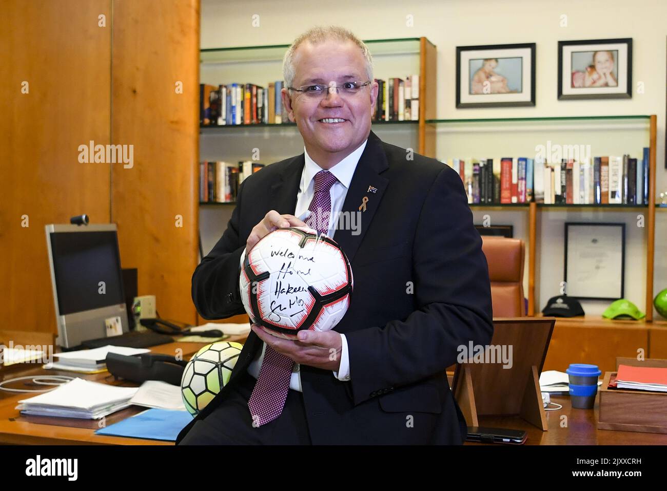 Australian Prime Minister Scott Morrison poses with a ball with a ...