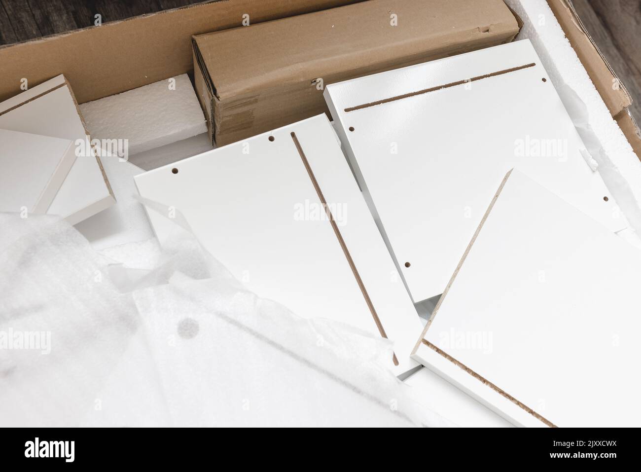 Opened box with furniture assembly parts and tools on the floor. Self ...