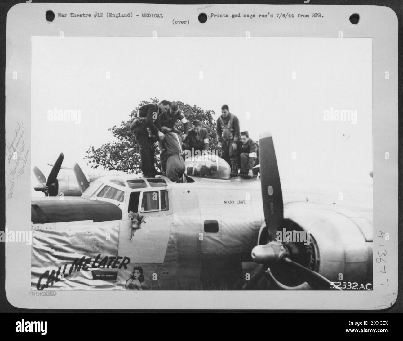A flak wound Consolidated B-24 Liberator top turret gunner is removed ...