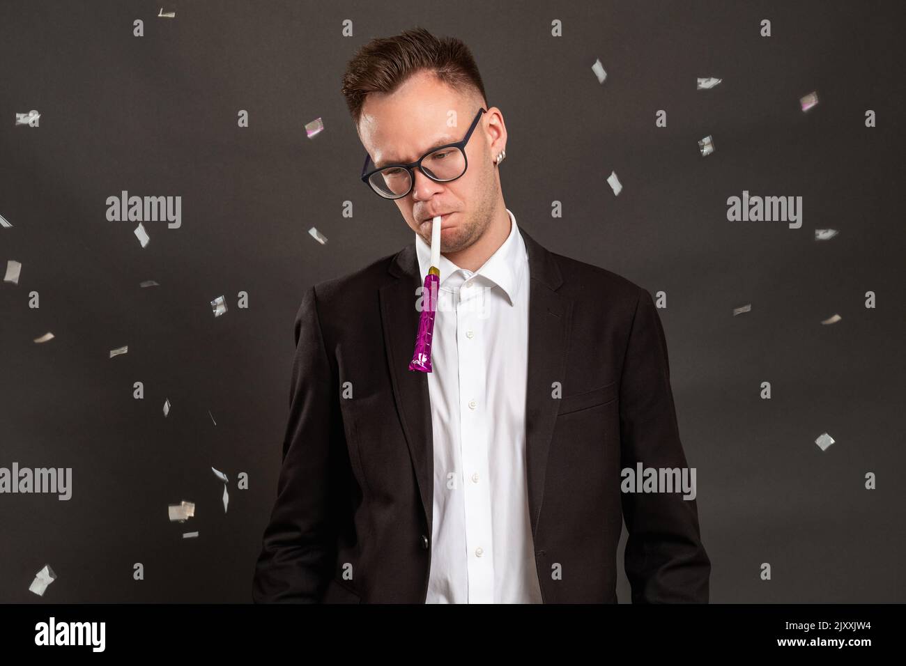 upset birthday guy sad party horn confetti rain Stock Photo - Alamy