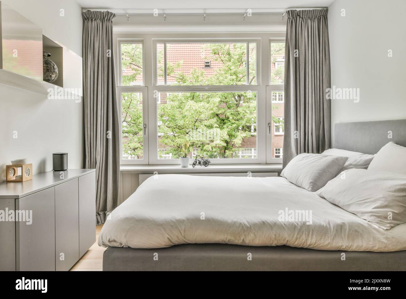 Interior of light bedroom with queen size bed, working desk and classic ...